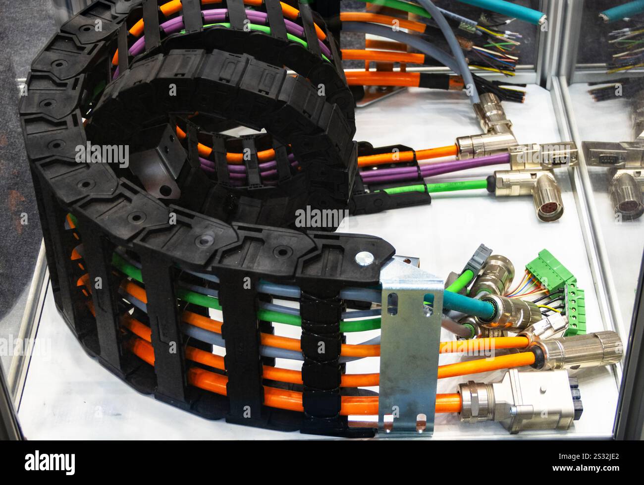 A black cable carrier, a drag chain, designed for industrial applications. The carrier is formed ...