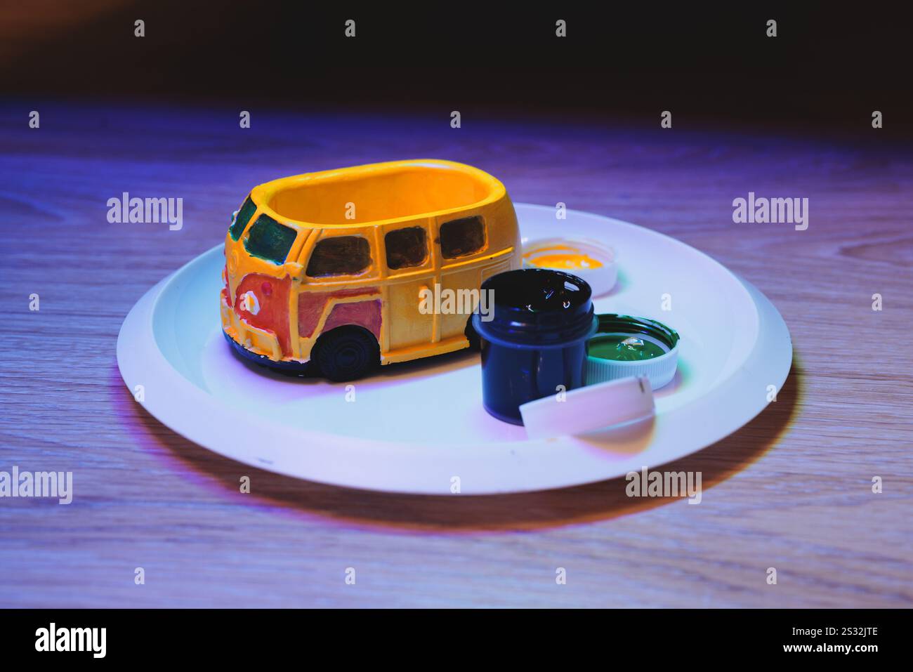 A vibrant and colorful miniature model of a VW Bus featuring paint pots ...