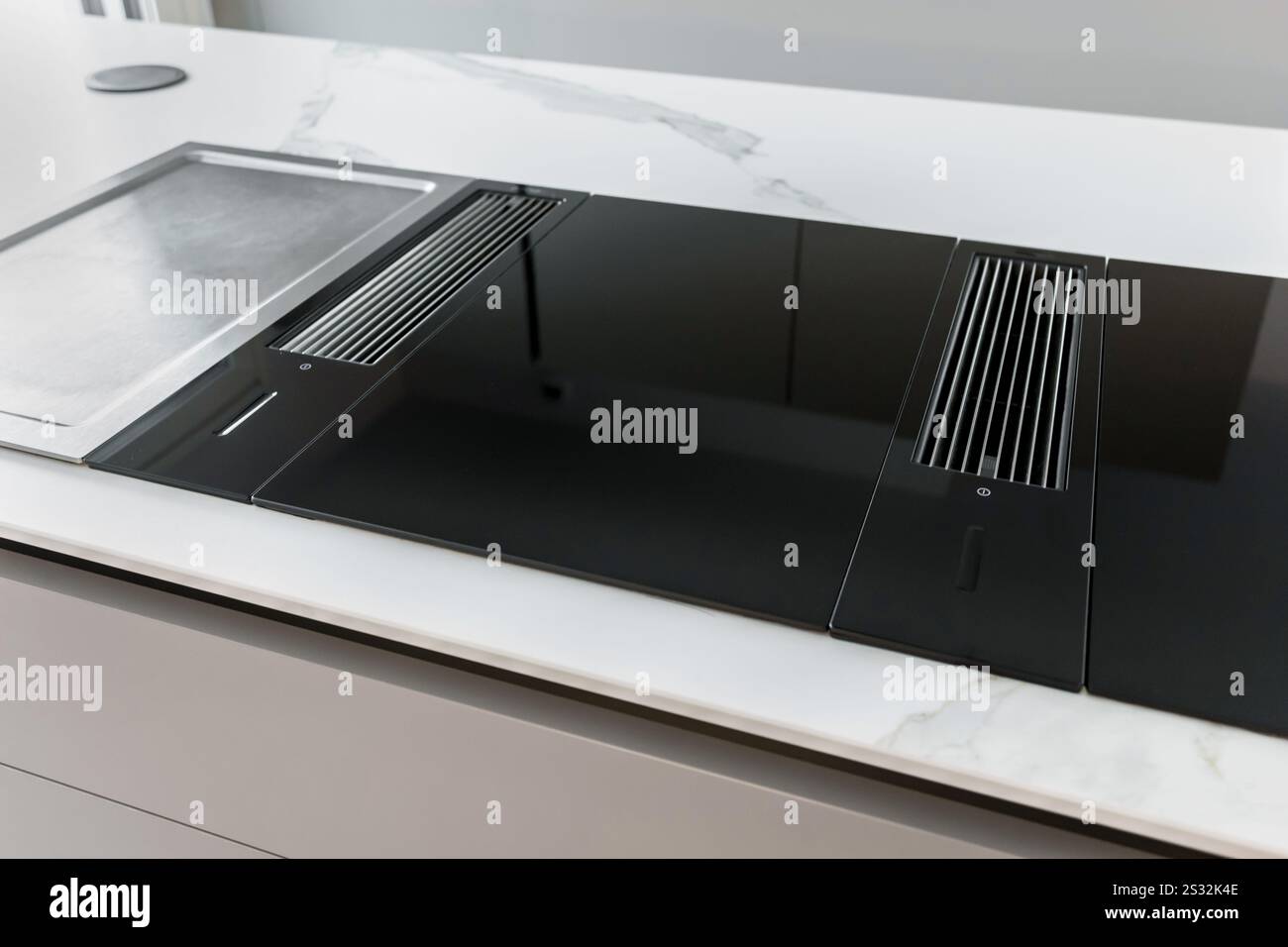 Closeup of Induction cooker black glass hob with integrated hood or ...