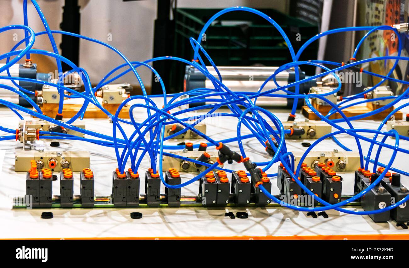 A close-up of a hydraulic training rig with numerous blue hoses and ...