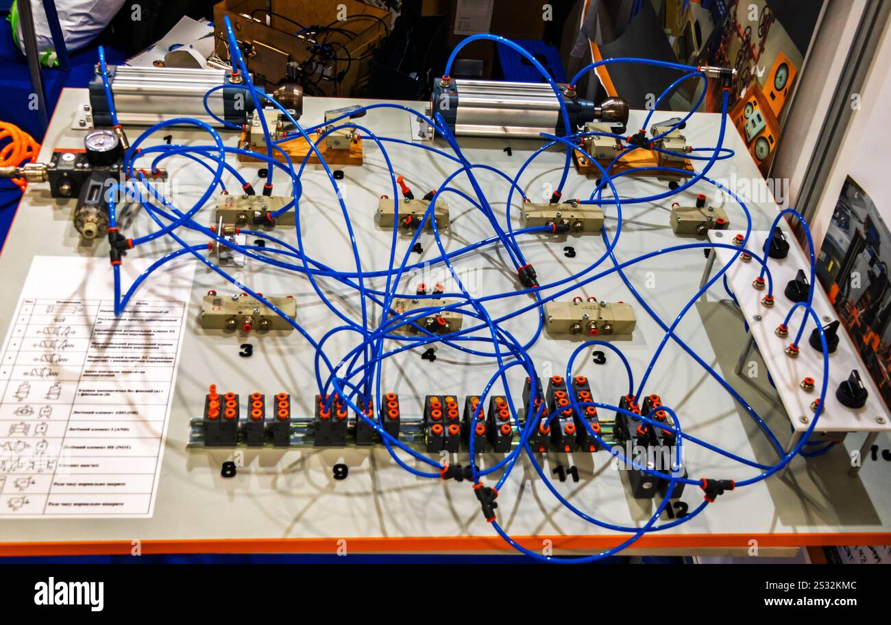 A close-up of a hydraulic training rig with numerous blue hoses and various valves connected to ...