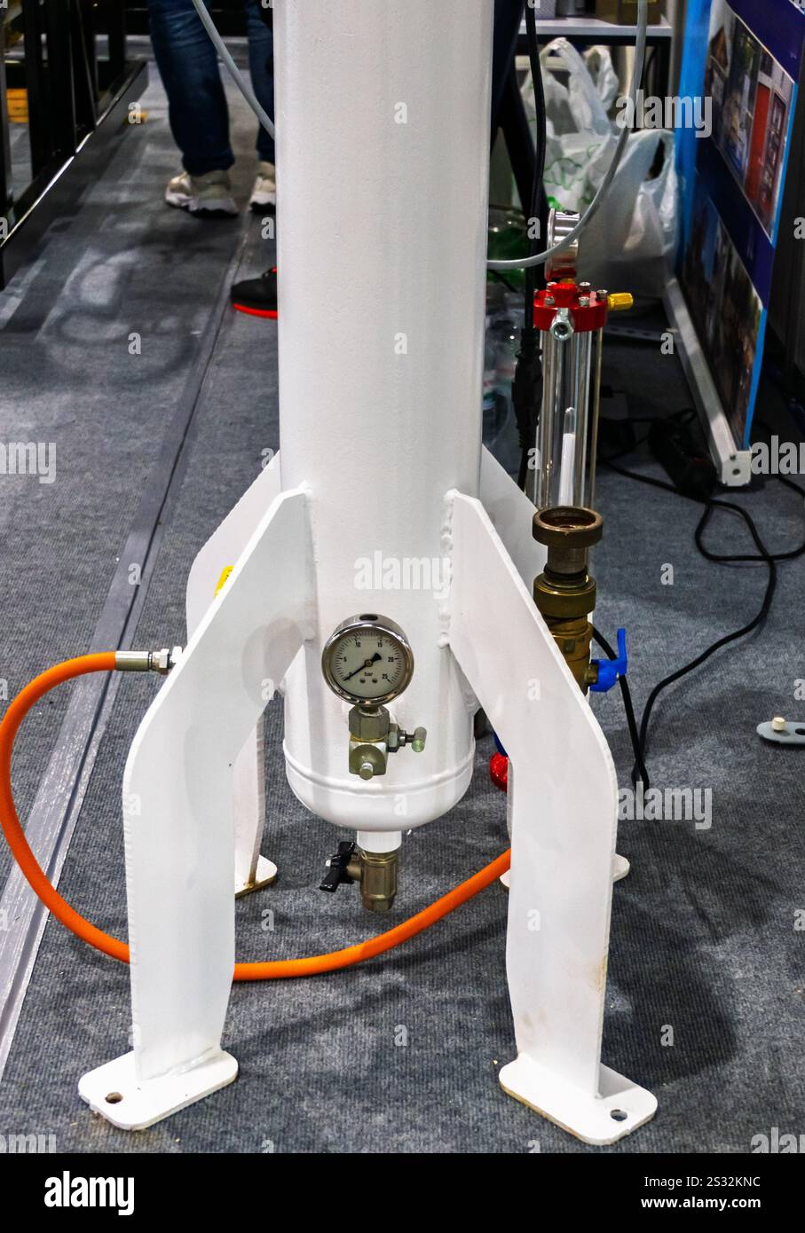 A white industrial compressed air tank with a pressure gauge and ...