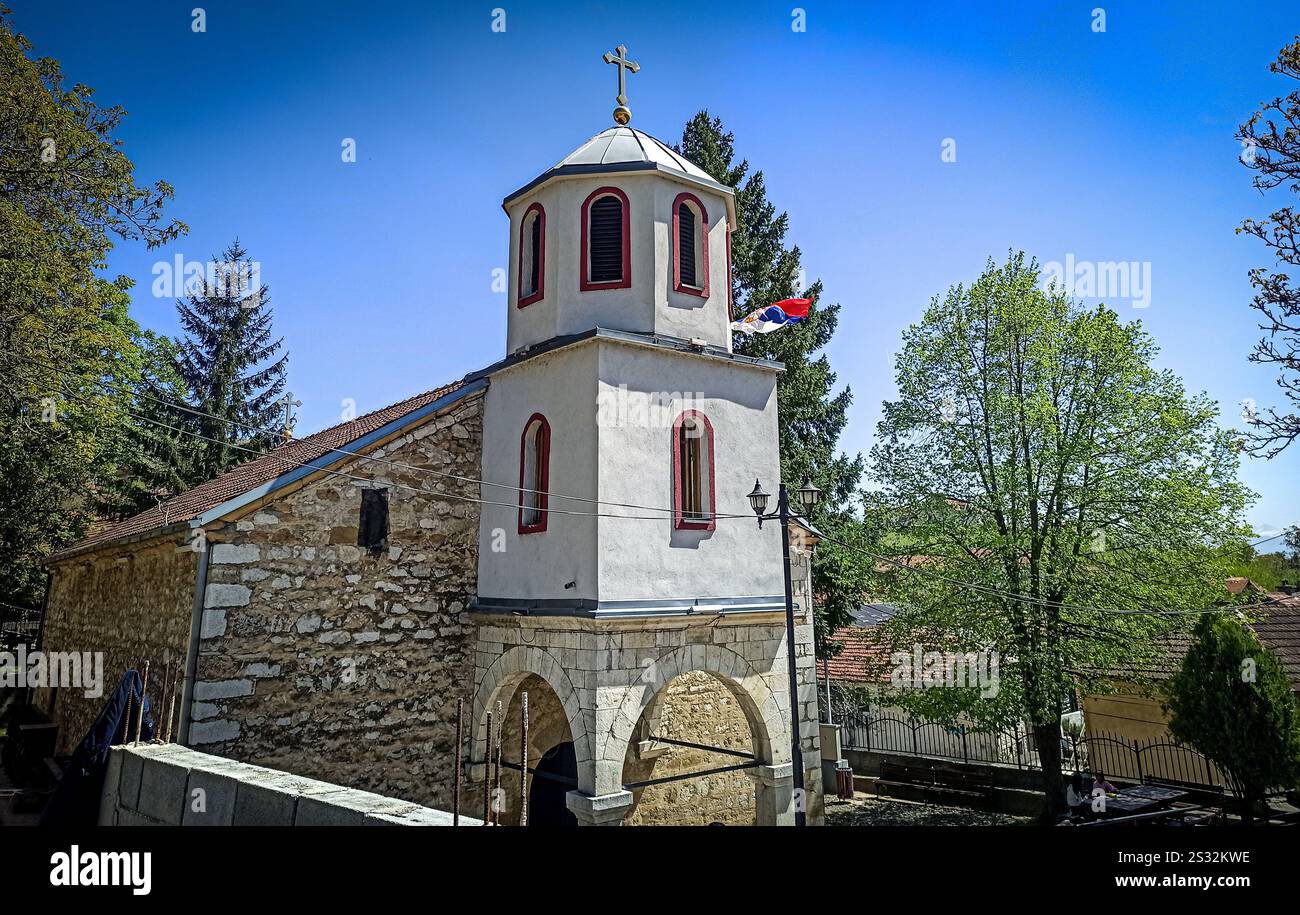 A quaint and small stone church featuring a tall tower along with a ...