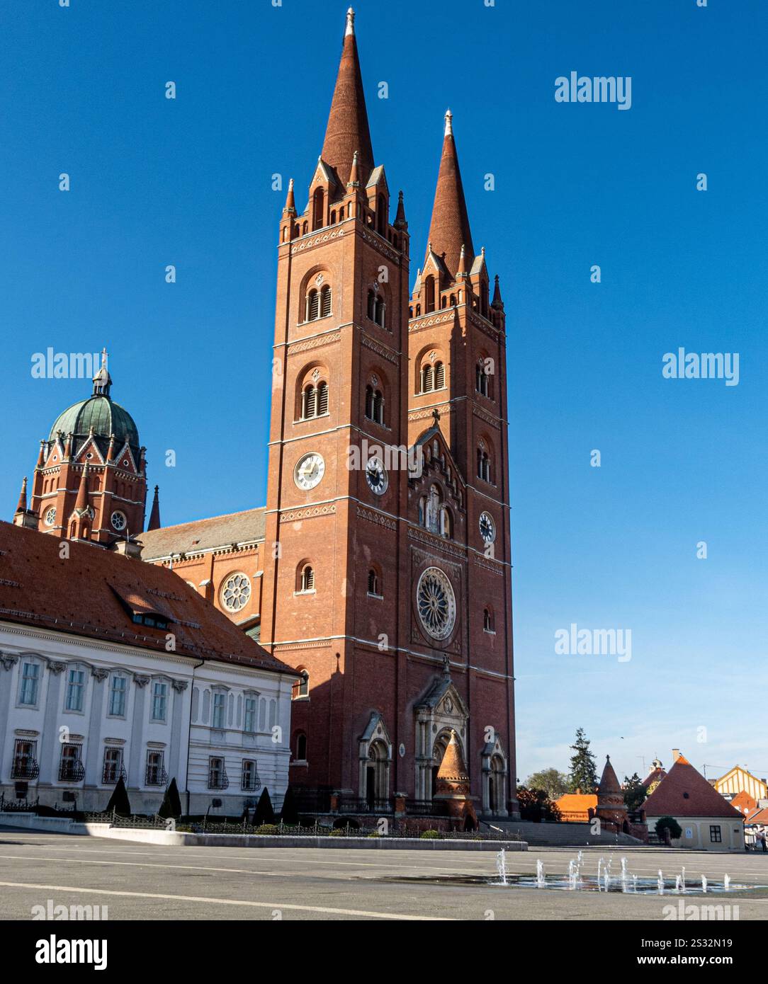 A large, striking red brick building featuring two impressive towers ...