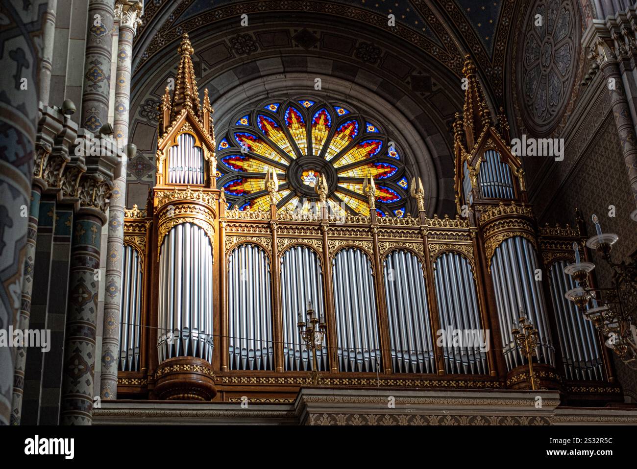 Inside a vast church, theres a magnificent organ prominently displayed ...