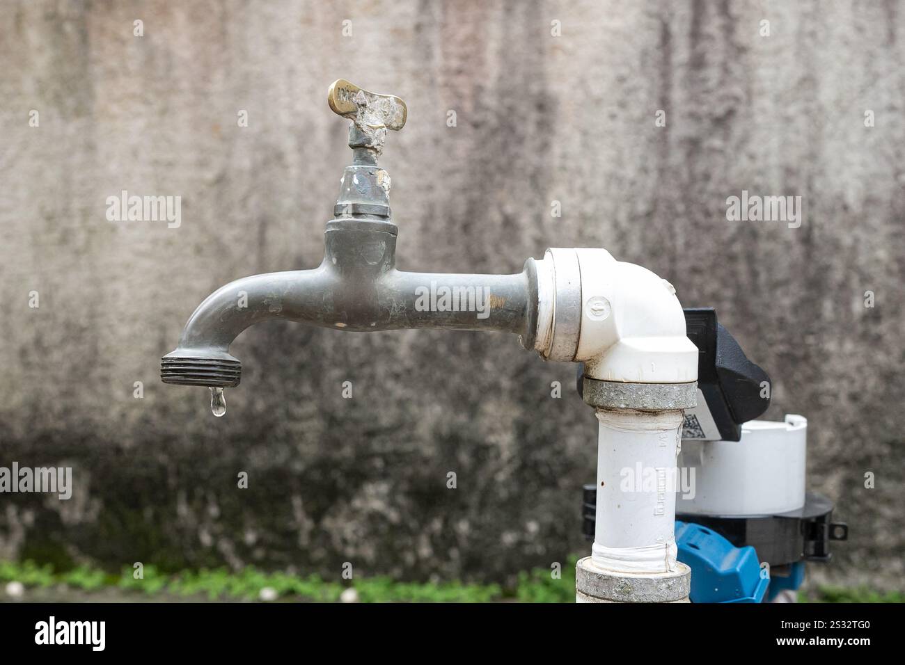 Water tap with the focus on its spout. The photo has neutral colors and ...