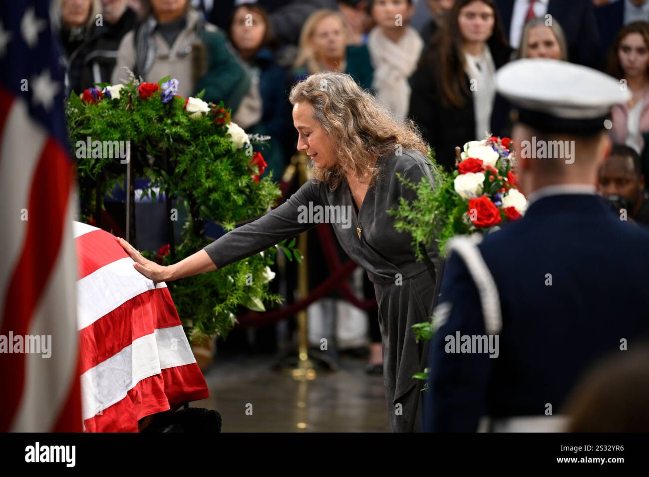 A Human Rights Partners Group member touches the flag-draped casket of ...