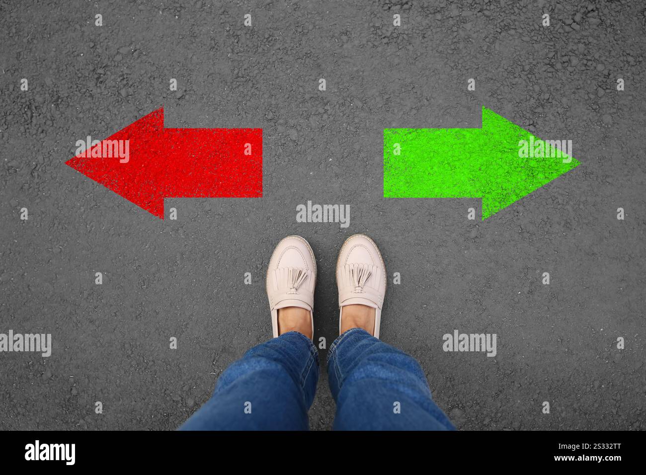 Woman standing near arrows pointing in different directions on asphalt ...