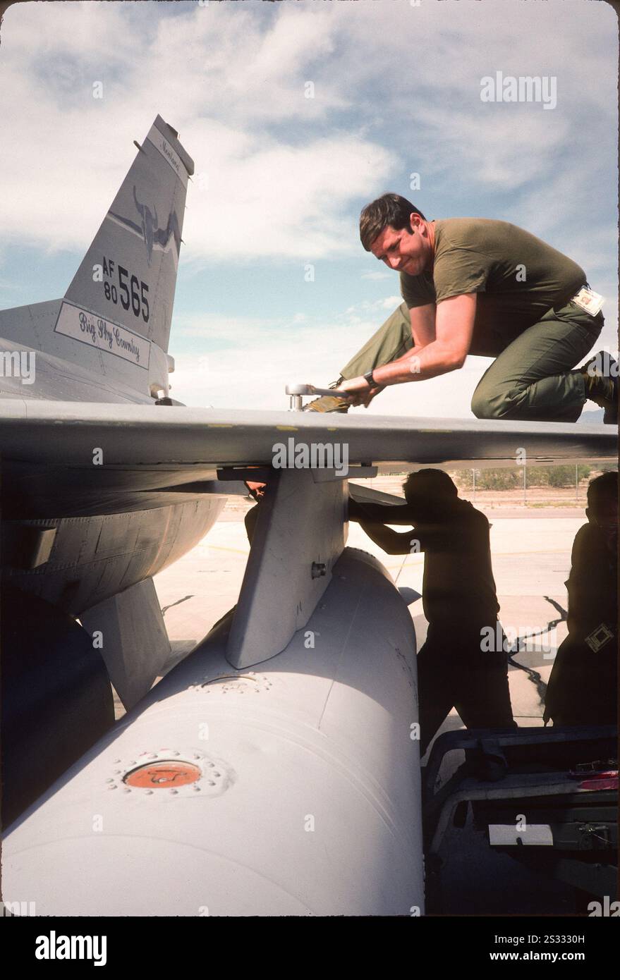 Maintenance crew loads the left wing tank on an F-16A. Det 1, 120 FIG ...