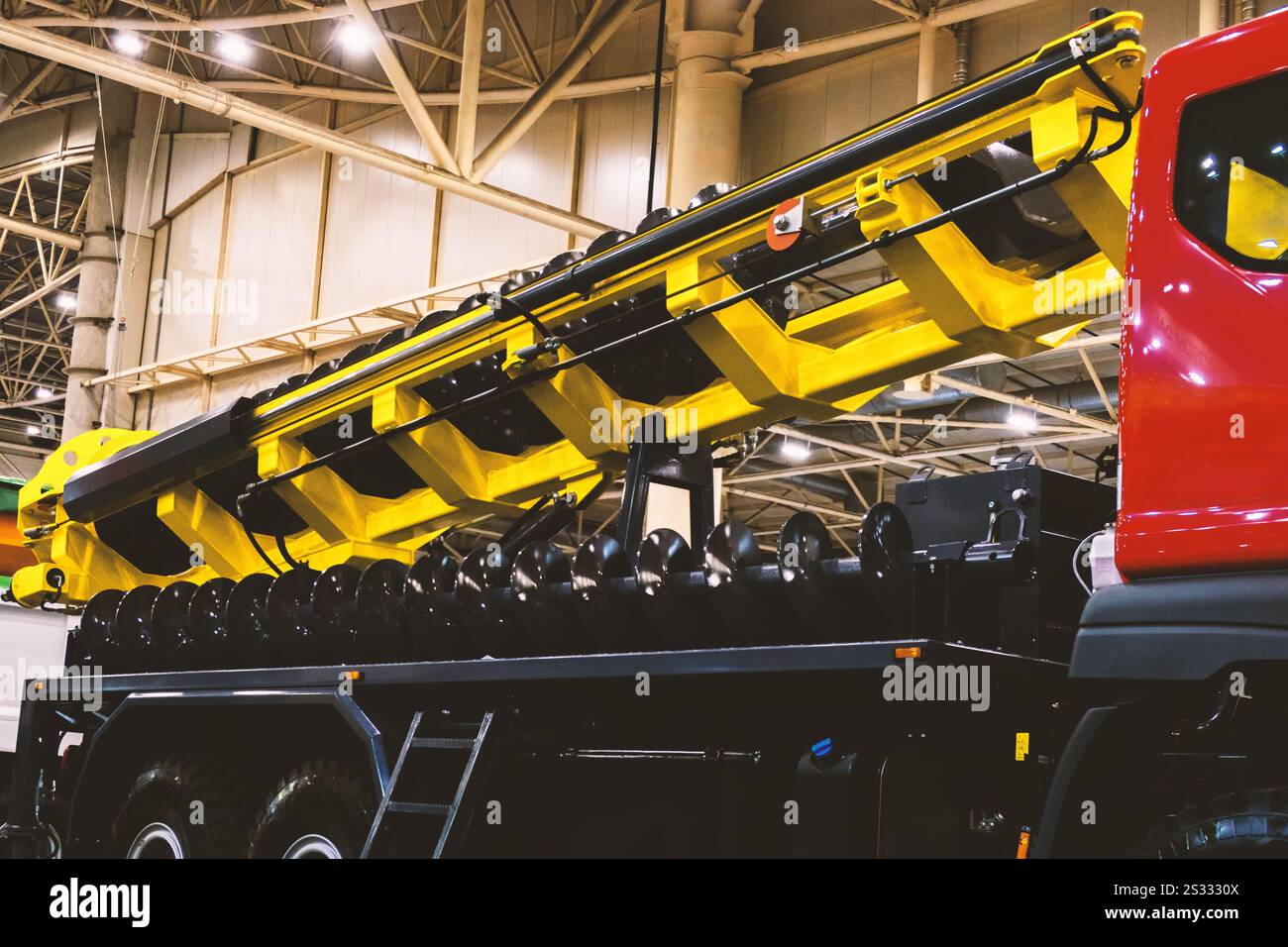 A drilling rig mounted on a truck, featuring a yellow boom and drilling ...