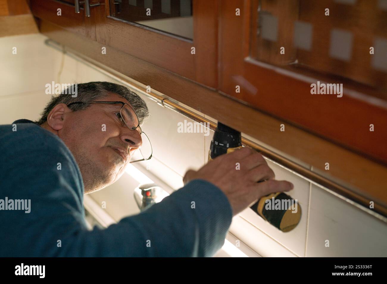 Electrical technician installing led lighting with a drill Stock Photo ...