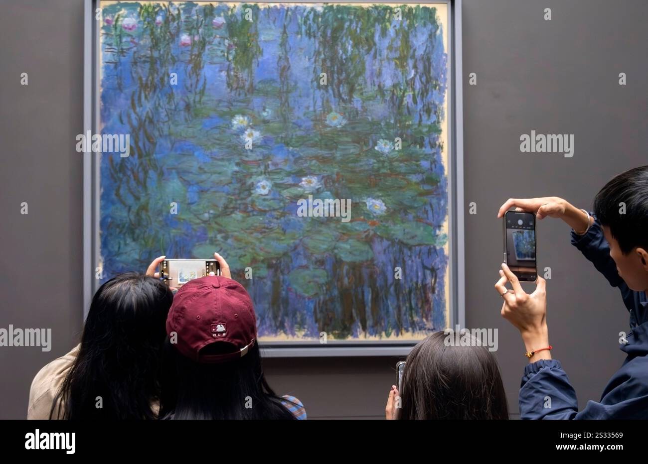 people looking and photographing Claude Monet's Water Lillies painting ...