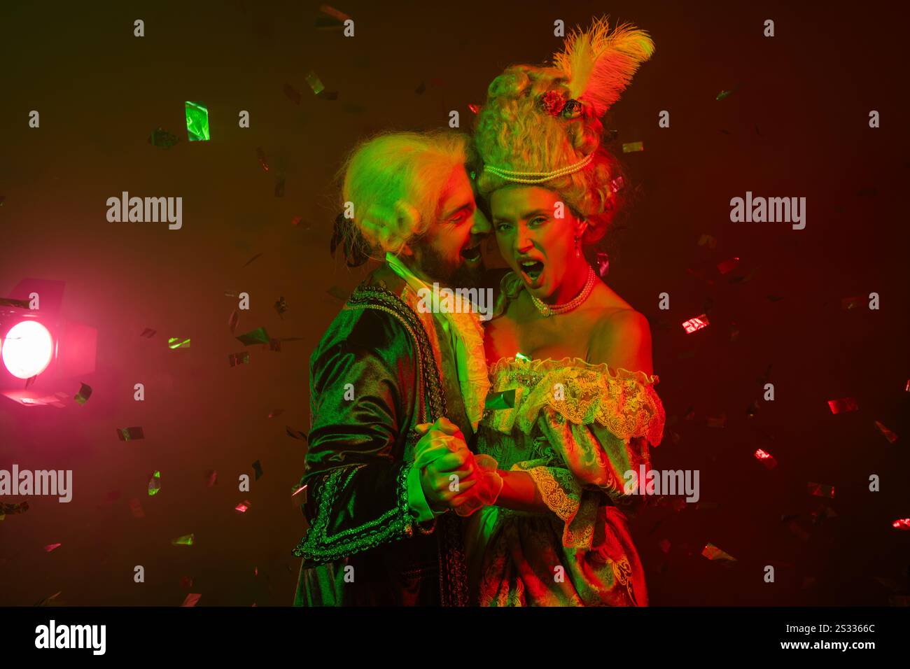 Young couple wearing aristocratic costumes in a dramatic light setting ...