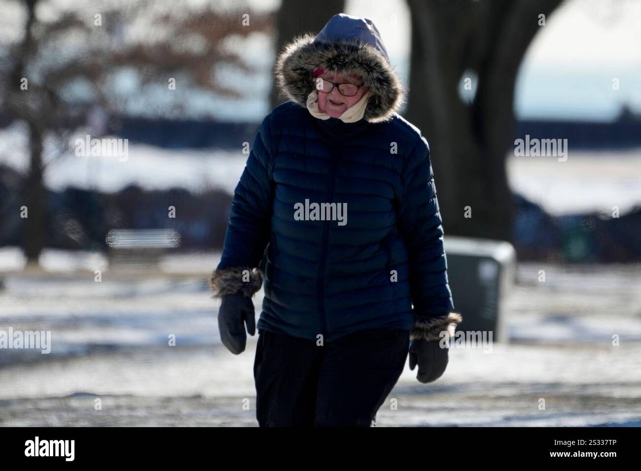 A pedestrian bundles up as she takes a walk during cold weather in ...