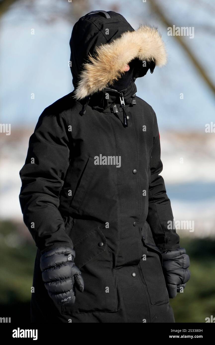 A pedestrian bundles up as she takes a walk during cold weather in ...