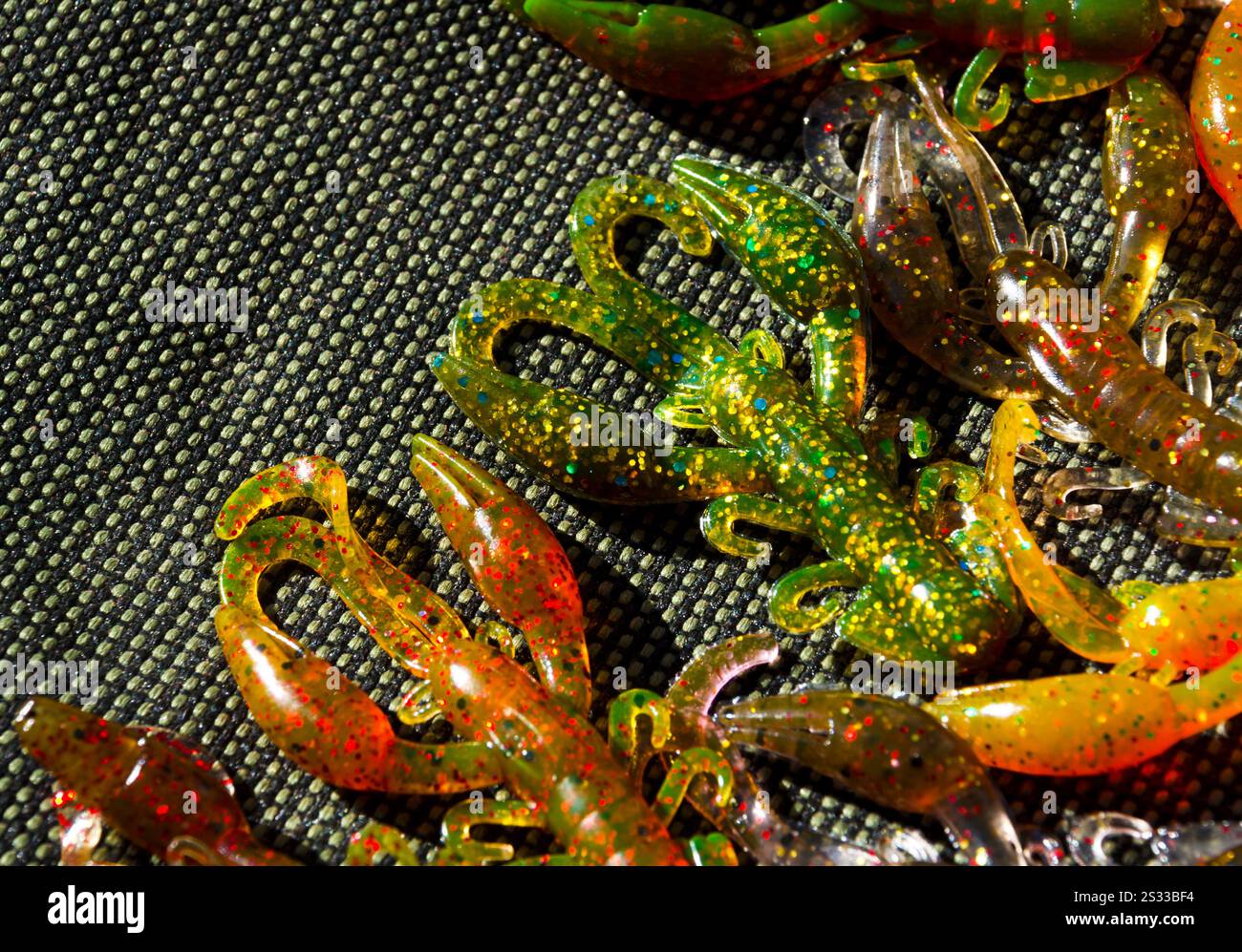 Silicone fishing bait in the shape of a crayfish on a green background ...