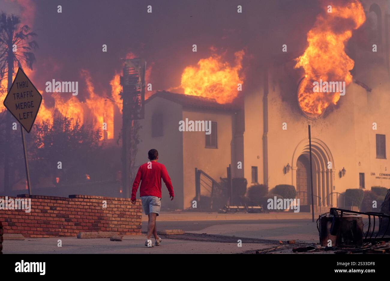 A man walks in front of the burning Altadena Community Church ...