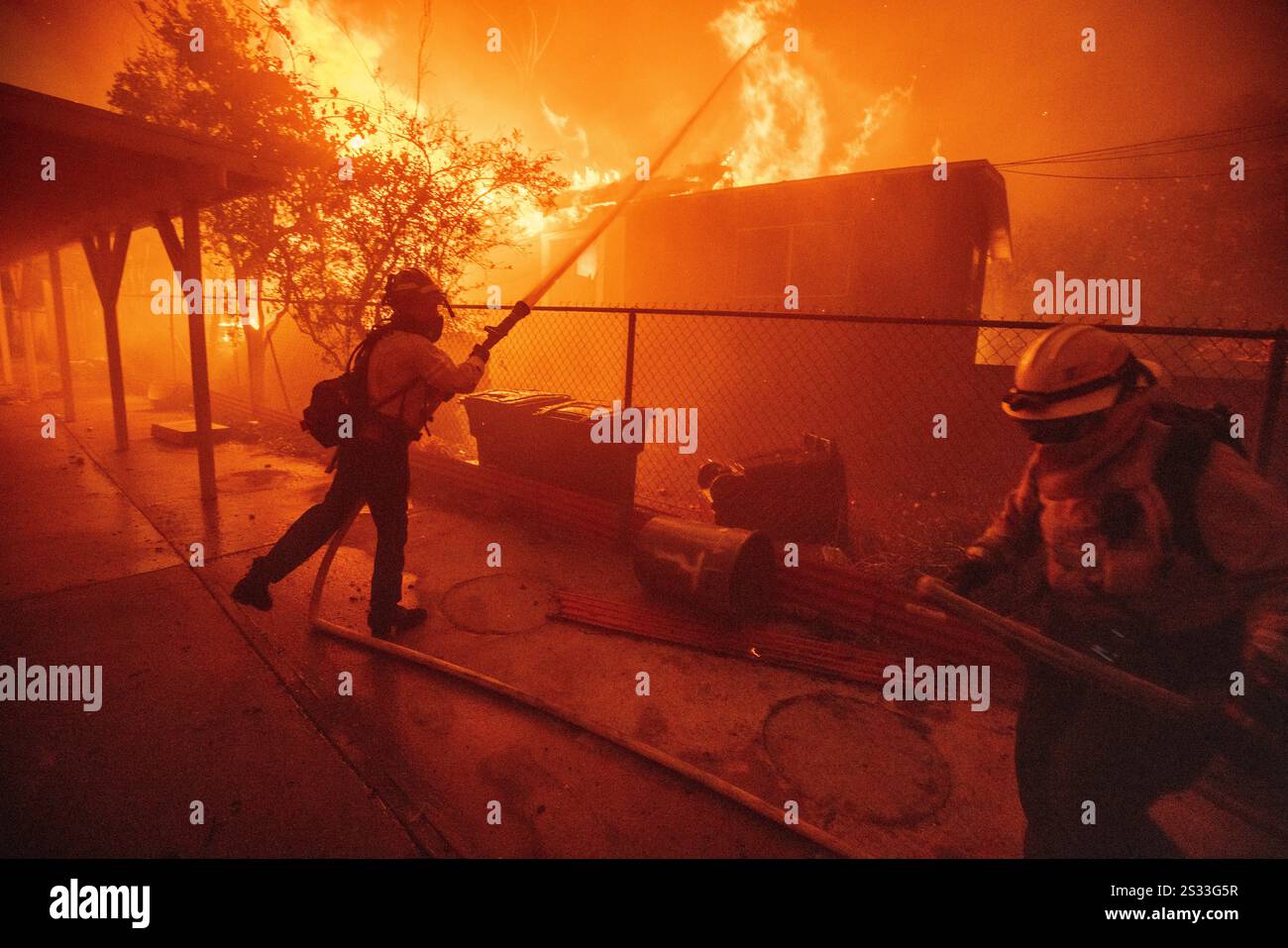 Firefighters protect a structure as the Eaton Fire advances Wednesday ...