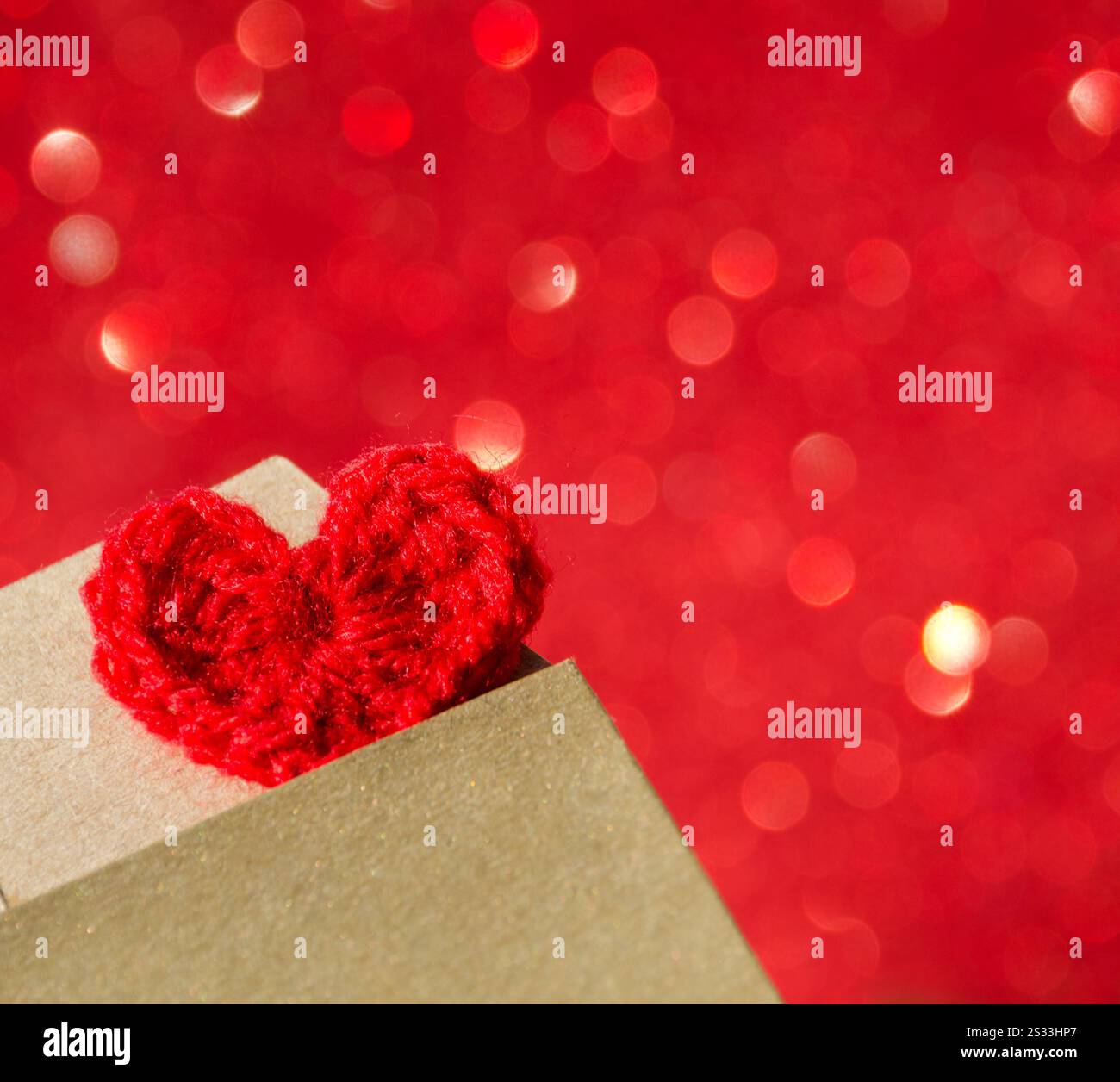 Heart in an envelope in honor of Valentine's Day on a red, blurry and ...