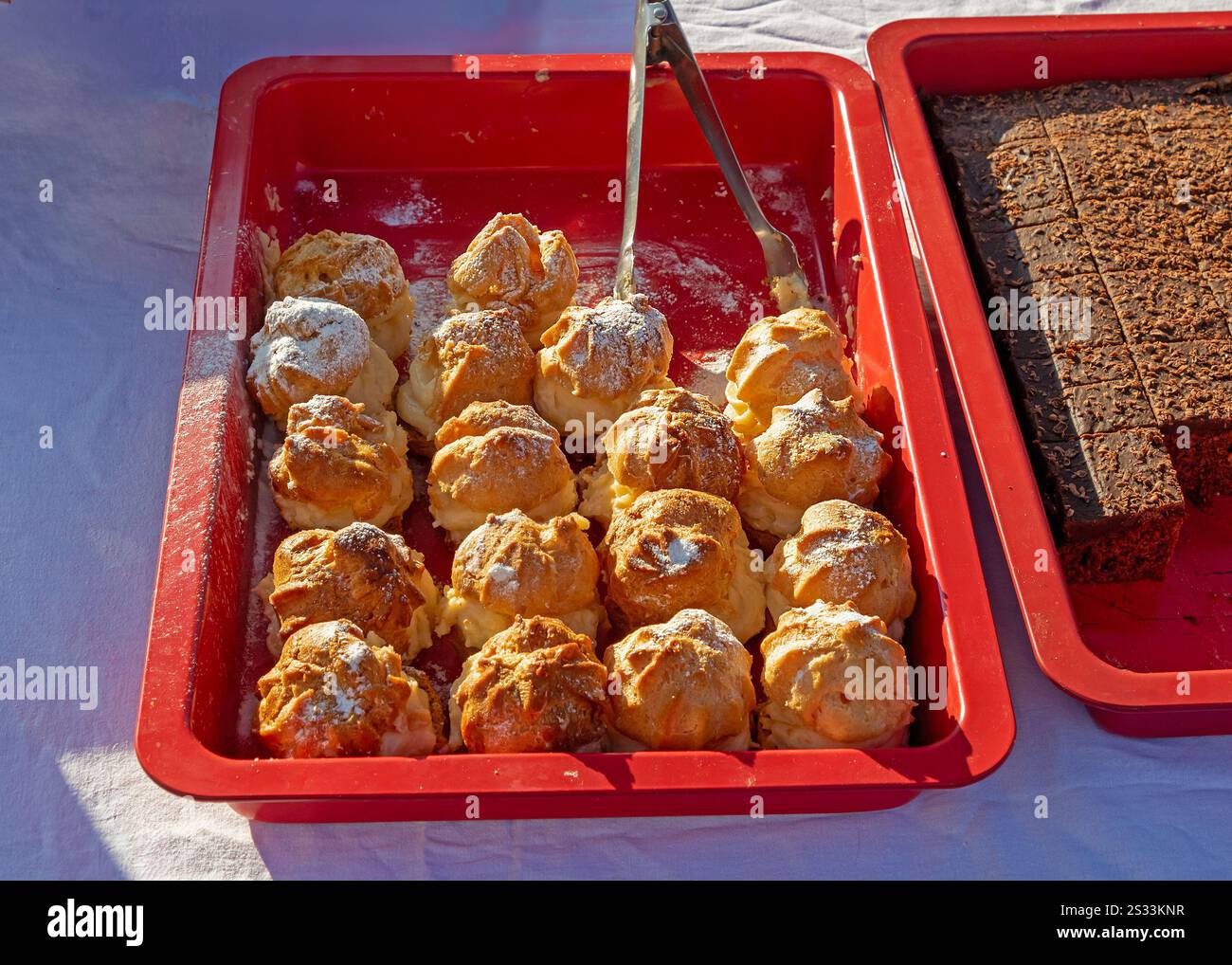 Sweet cream puffs dessert in tray sold outside on a market stall Stock ...