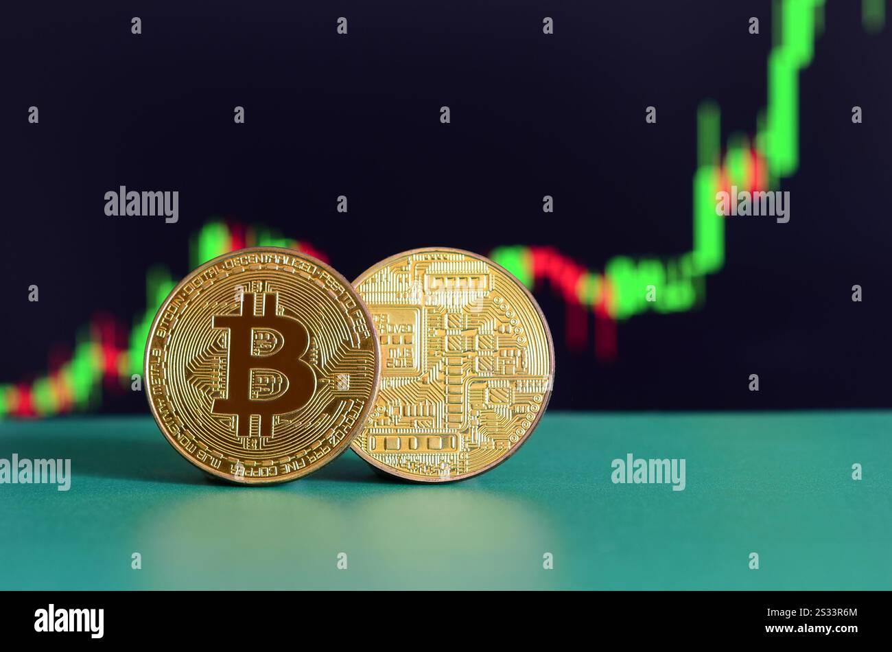 Two gold bitcoins lie on the green surface on the background of the ...