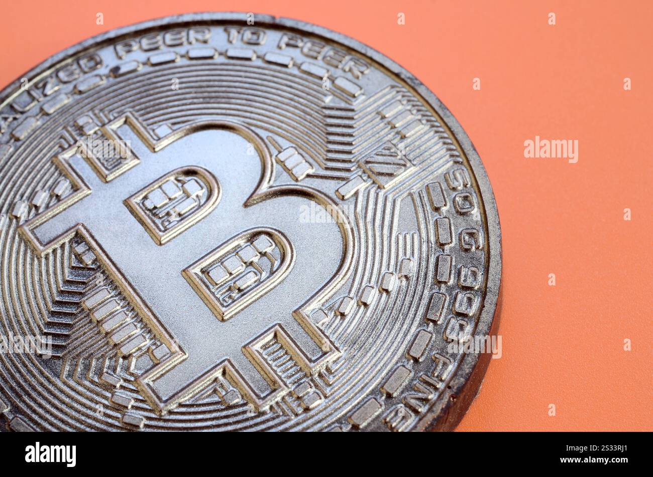 Chocolate product in the form of physical bitcoin lies on an orange ...