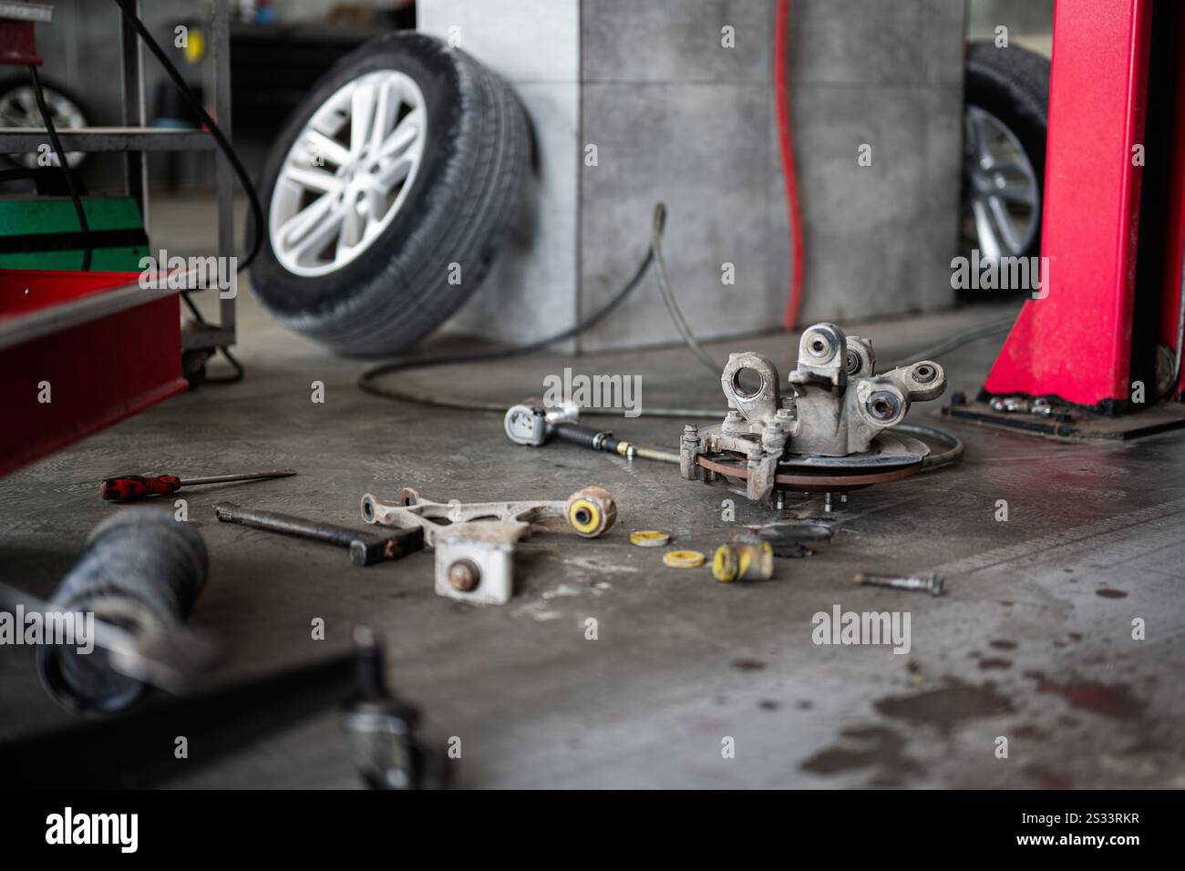 Mechanic's workshop displaying scattered car parts and tools ...