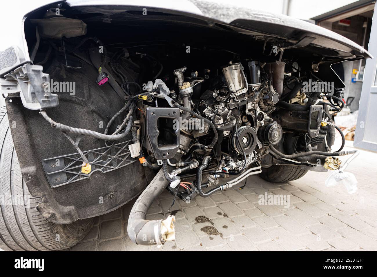 Close-up shot of an exposed car engine, showing mechanical components ...
