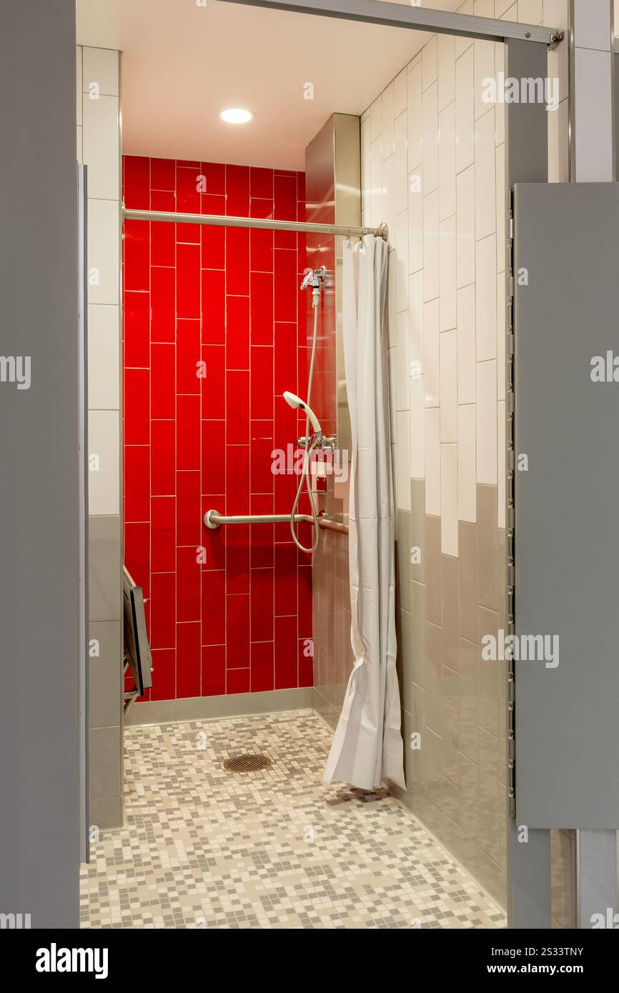 Vertical photo of a new single, private, gym locker room shower with ...