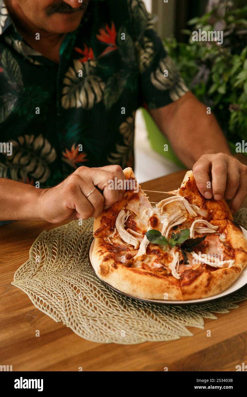 old man eats pizza in restaurant. Senior stylish modern man with ...