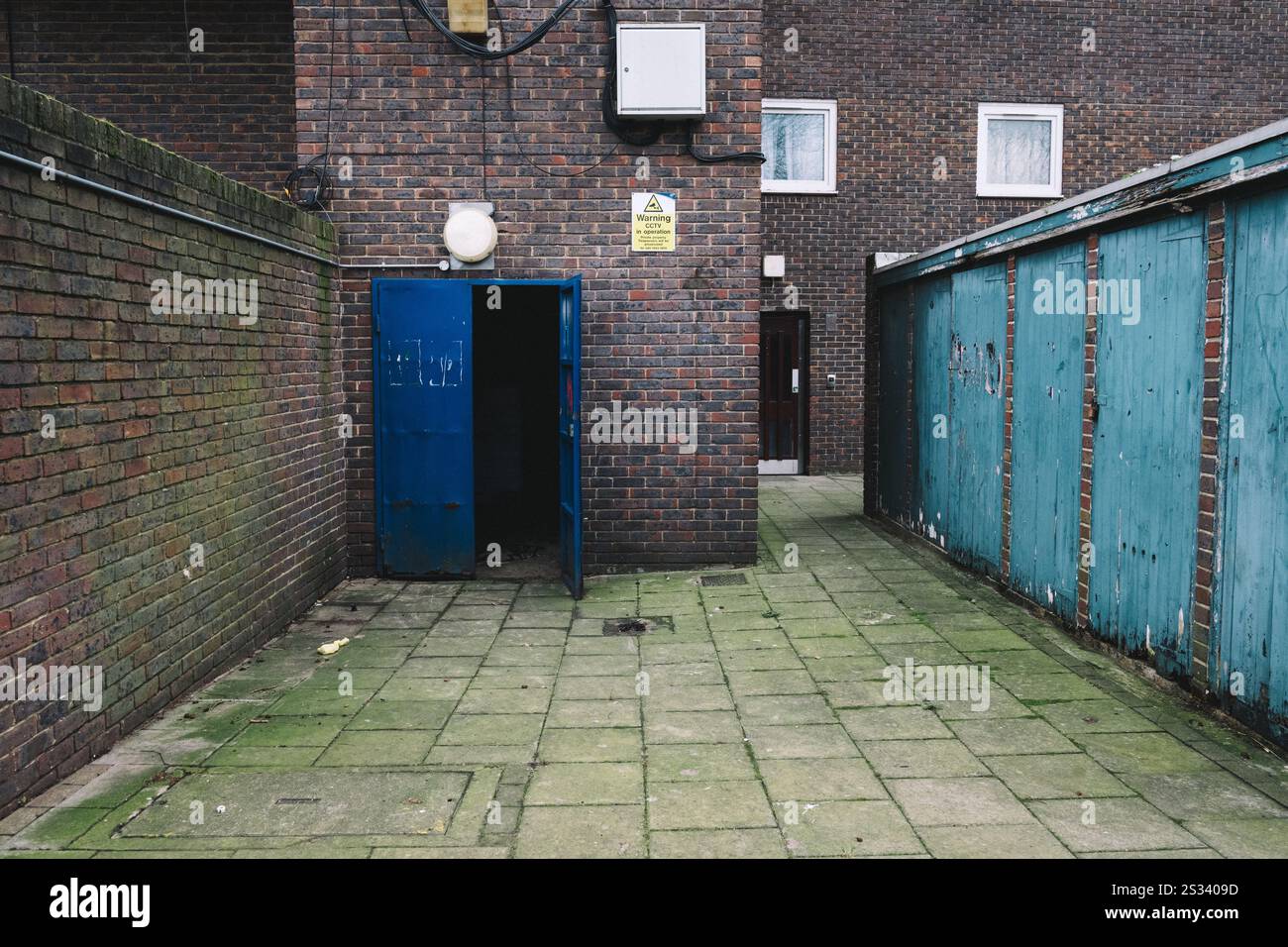 Urban Alleyway with Brick Walls and Open Blue Metal Doorway Stock Photo ...