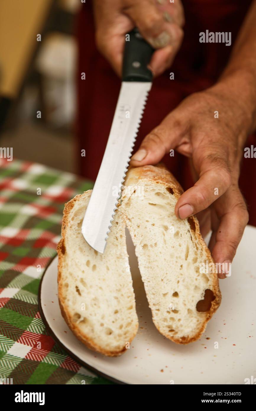 Homemade sourdough bread. Wheat rye flour. Man cuts the bread ...