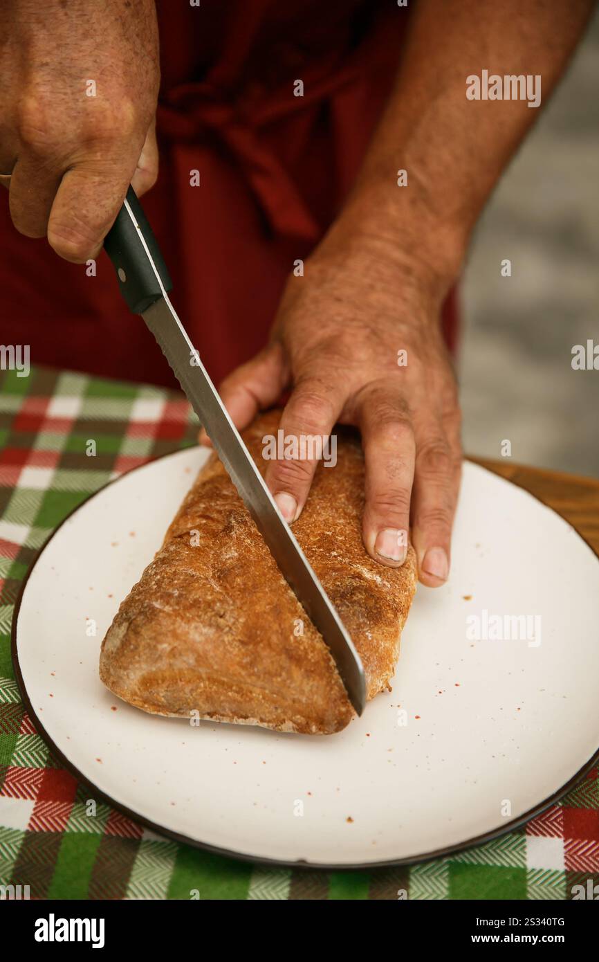 Homemade sourdough bread. Wheat rye flour. Man cuts the bread ...