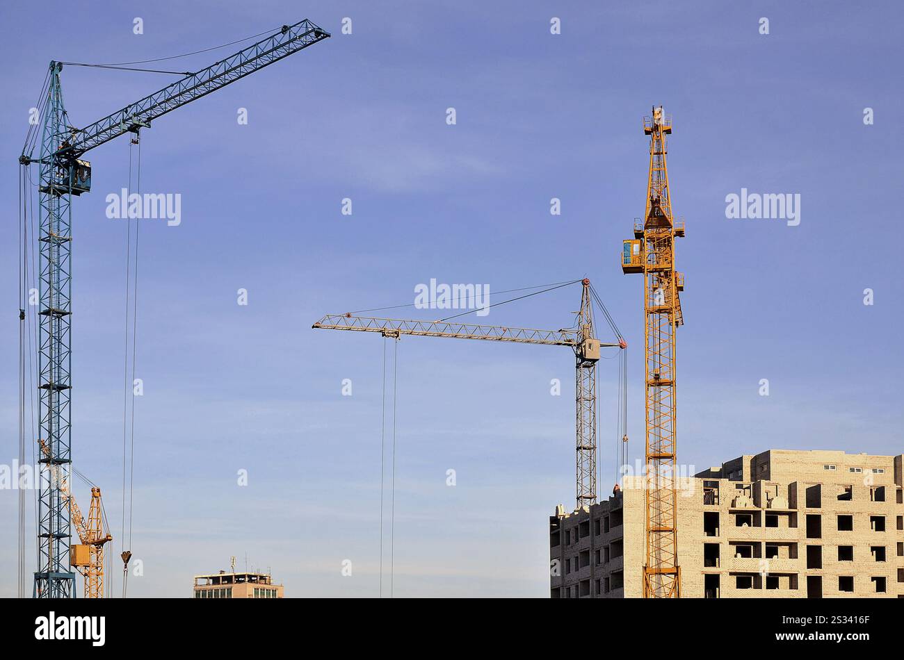 Working tall cranes inside place for with tall buildings under ...