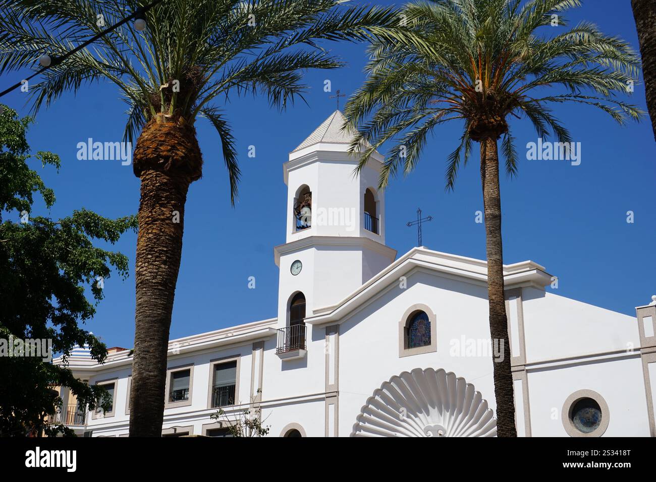The beautiful white facade of a historic Catholic church with a cross ...