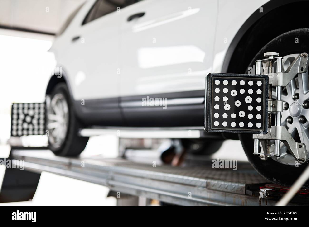 A close-up view of a car's wheel receiving a precise alignment check in ...