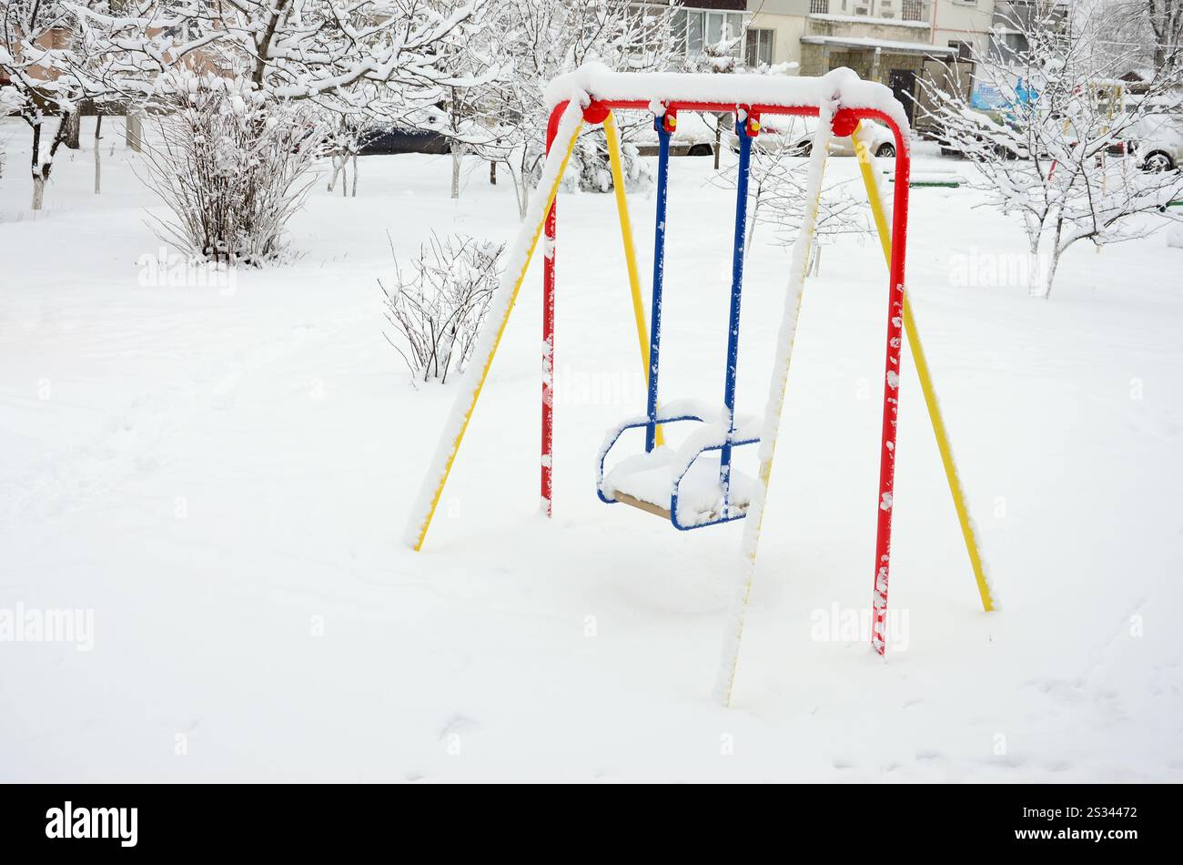 Children's swing, covered with a thick layer of snow after a heavy ...
