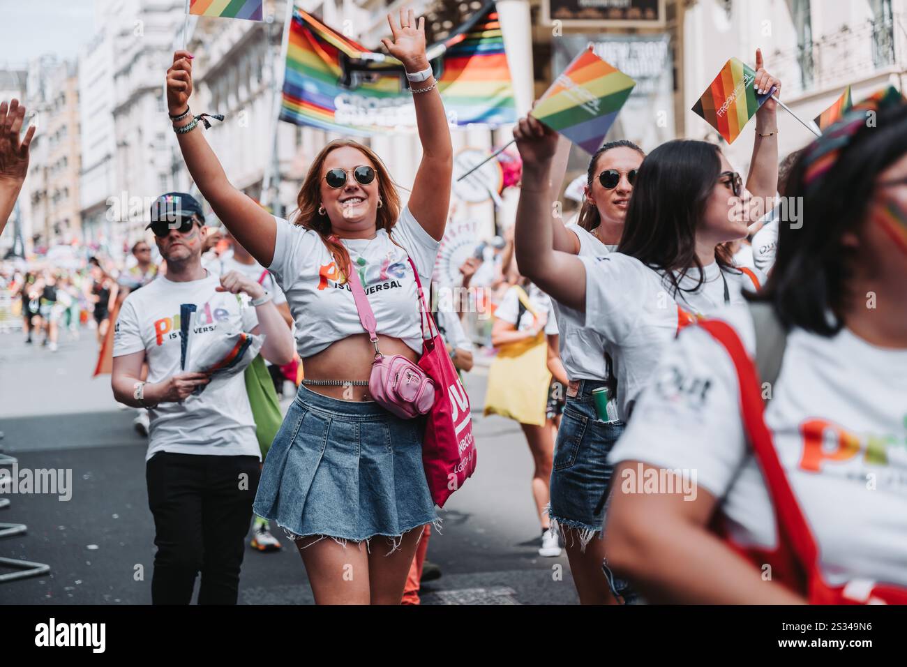Energetic participants waving rainbow flags as they march during the ...