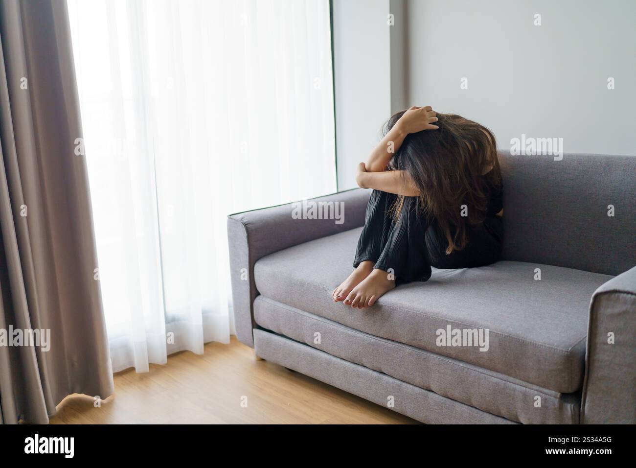 Sad woman thinking about problems sitting on a sofa upset girl feeling ...