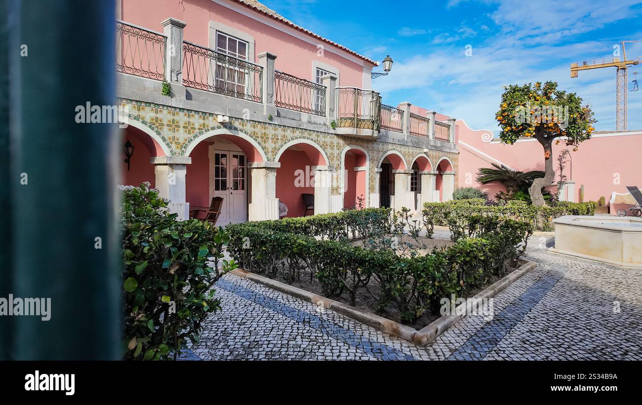 The courtyard of a house with pink walls in Faro, Portugal, providing a ...