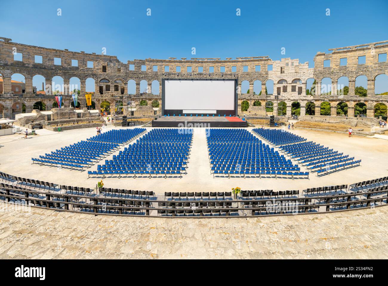 In the historic Roman amphitheatre of Pula, rows of blue chairs set the ...