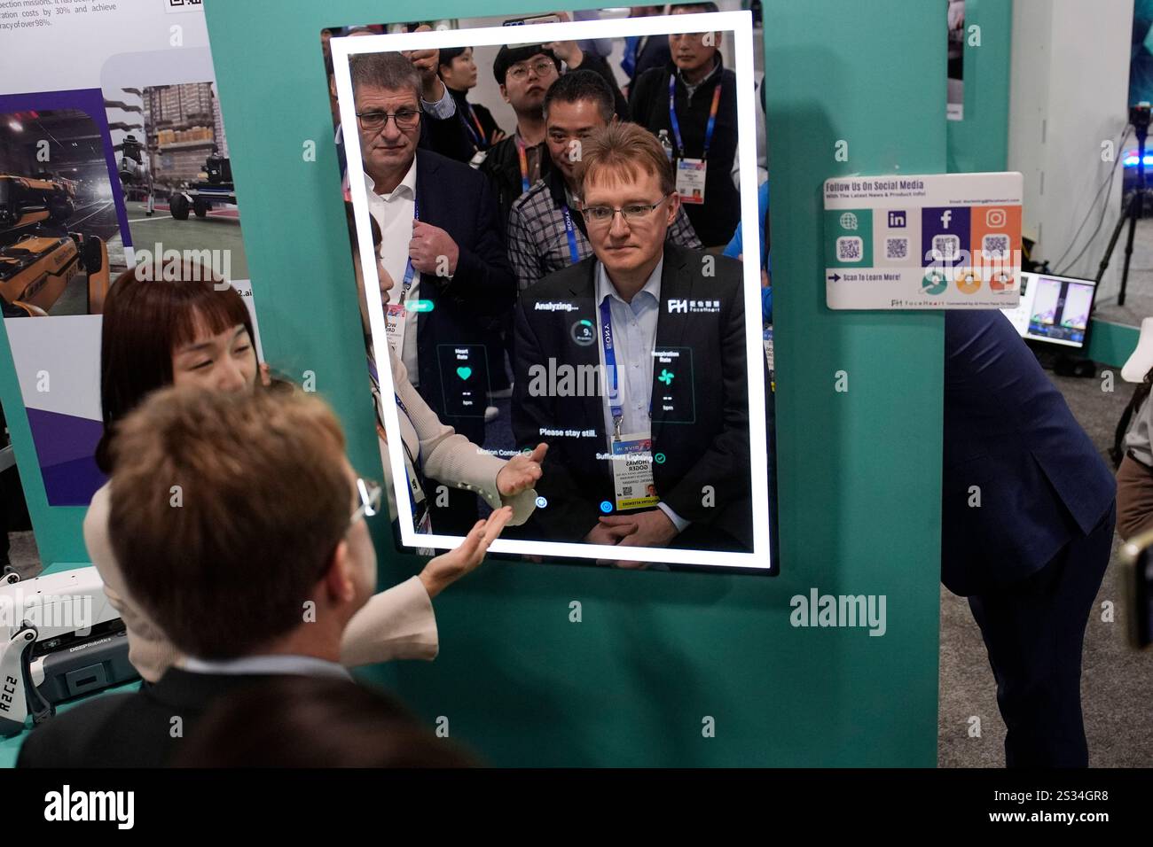 Attendees look at the FaceHeart CardioMirror, an AI-powered smart ...