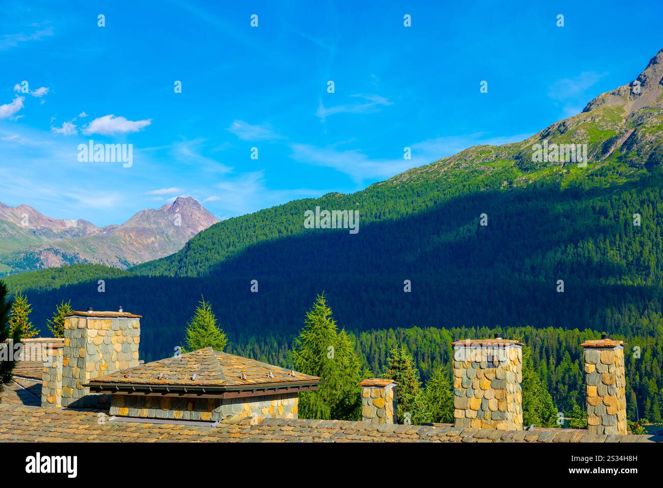 Rooftop with Chimney and Mountain Range and Blue Sky with Clouds in a ...
