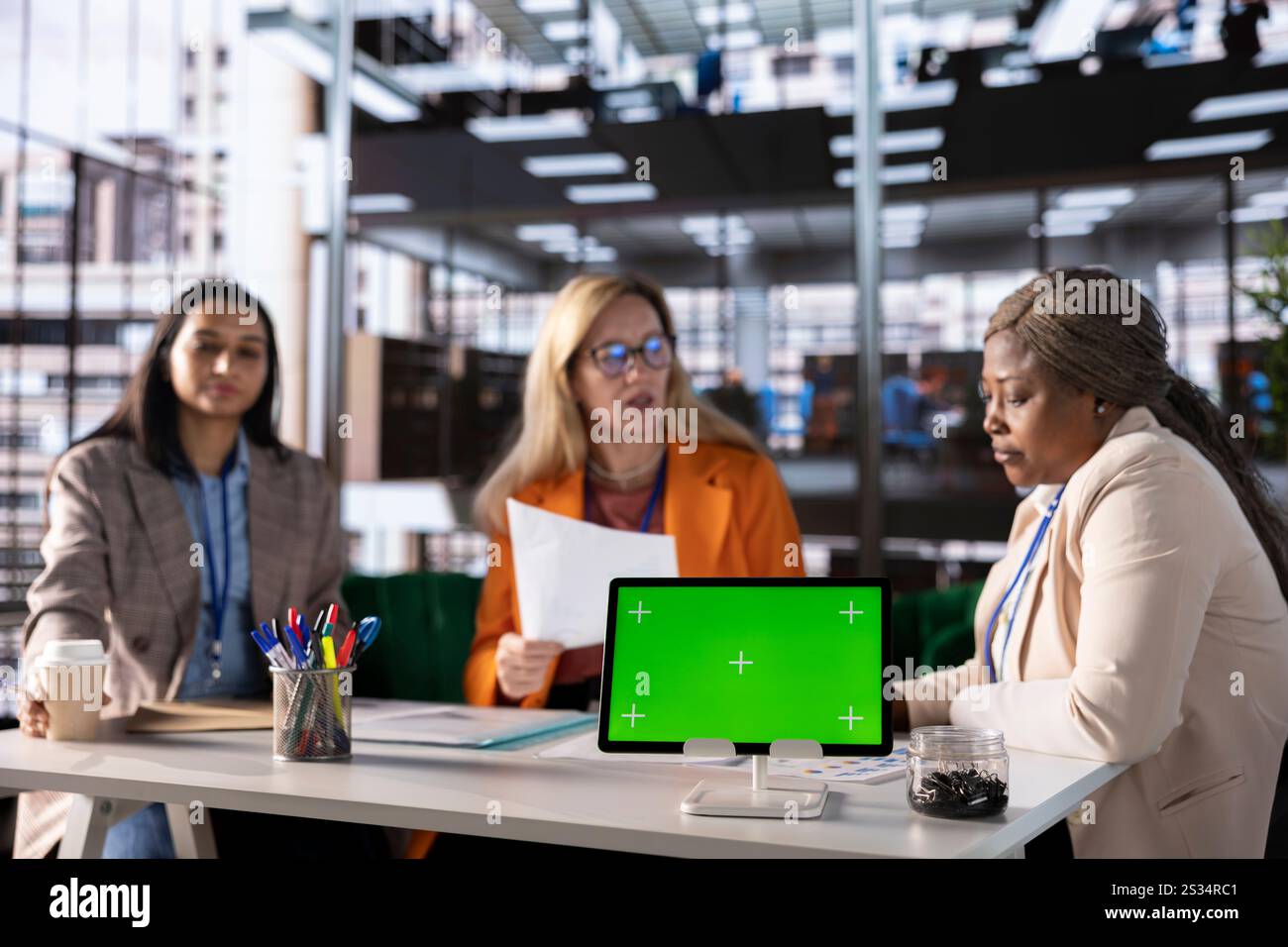 Diverse group of female colleagues ensuring goals achievement next to ...