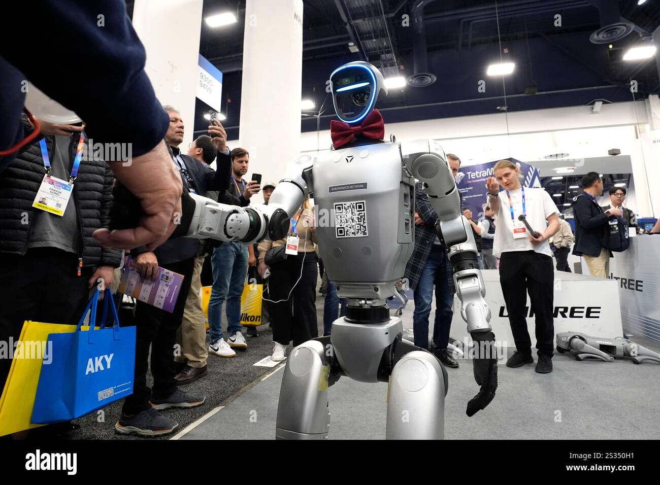 A Unitree H1 robot shakes the hand of an attendee at the CES tech show ...