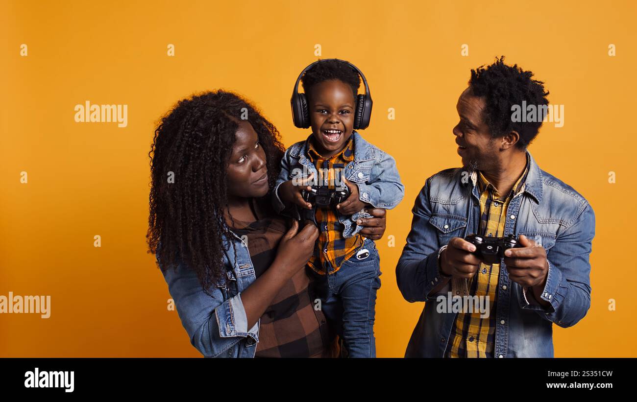Joyful optimistic dad playing online video games with his boy using ...