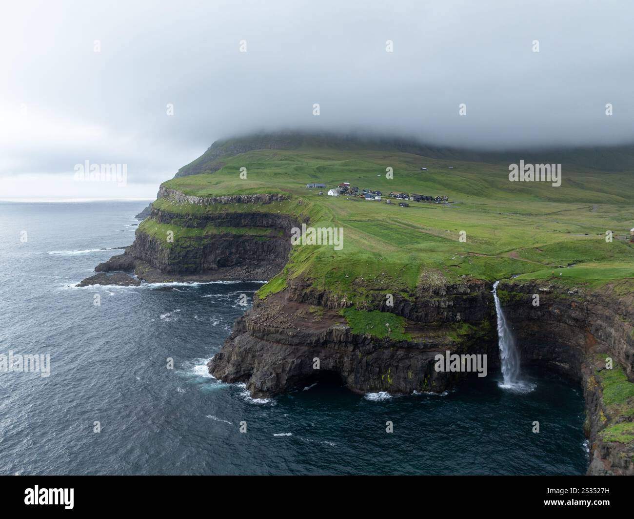 Aerial view of Gasadalur Village and Mulafossur Waterfall in the Faroe ...
