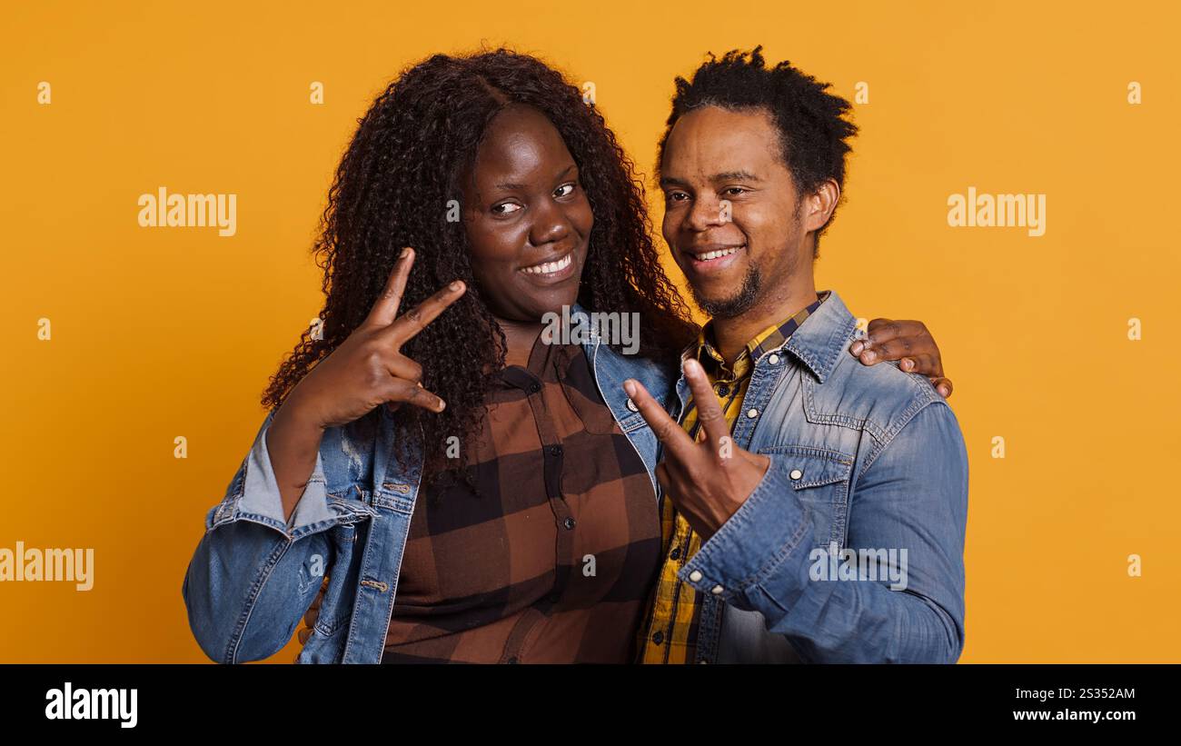 Cute life partners posing in studio and doing peace sign in studio ...