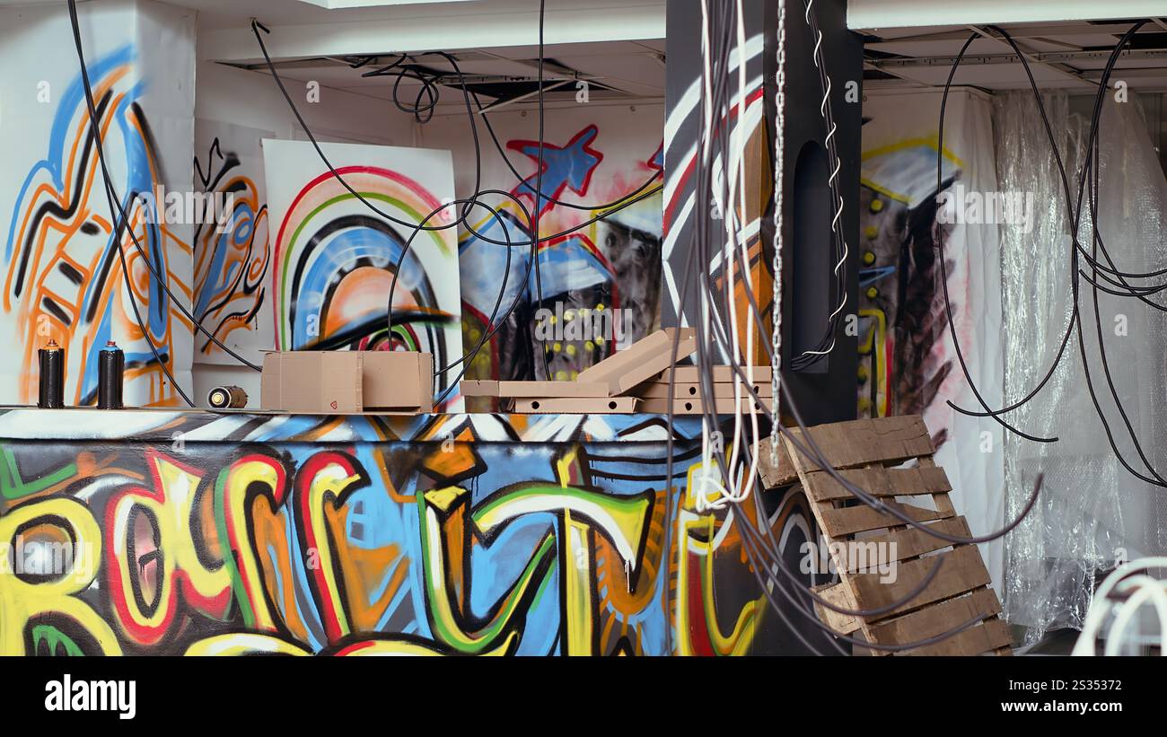 Panning shot of spraying paint cans in defaced building with colorful ...