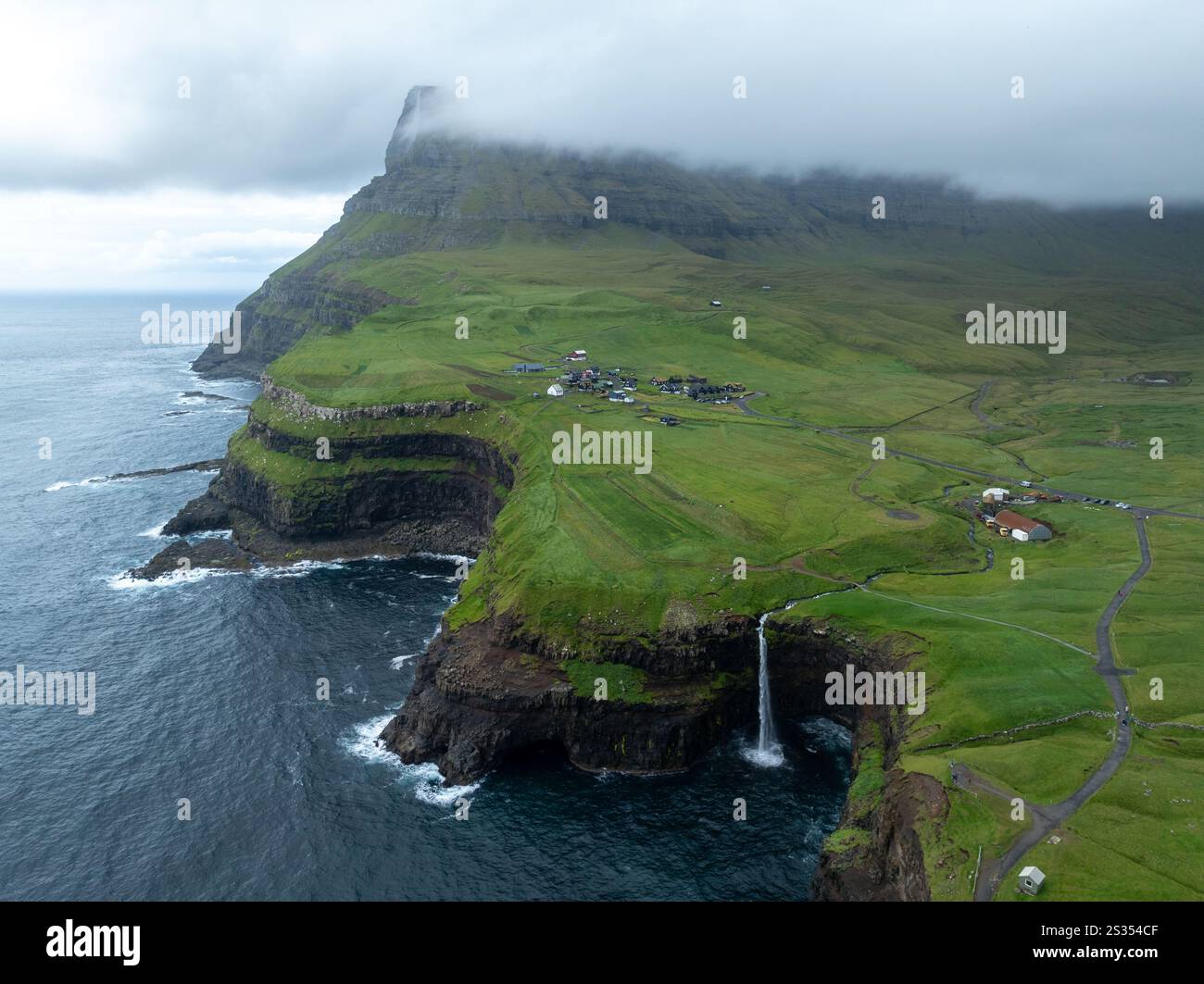 Aerial view of Gasadalur Village and Mulafossur Waterfall in the Faroe ...